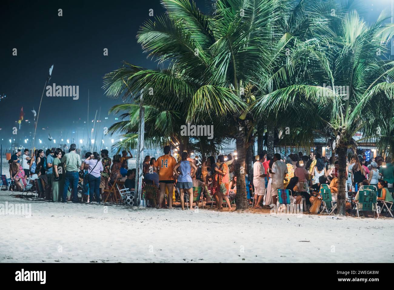 Night view of people socializing and drinking at an outdoor bar on ...