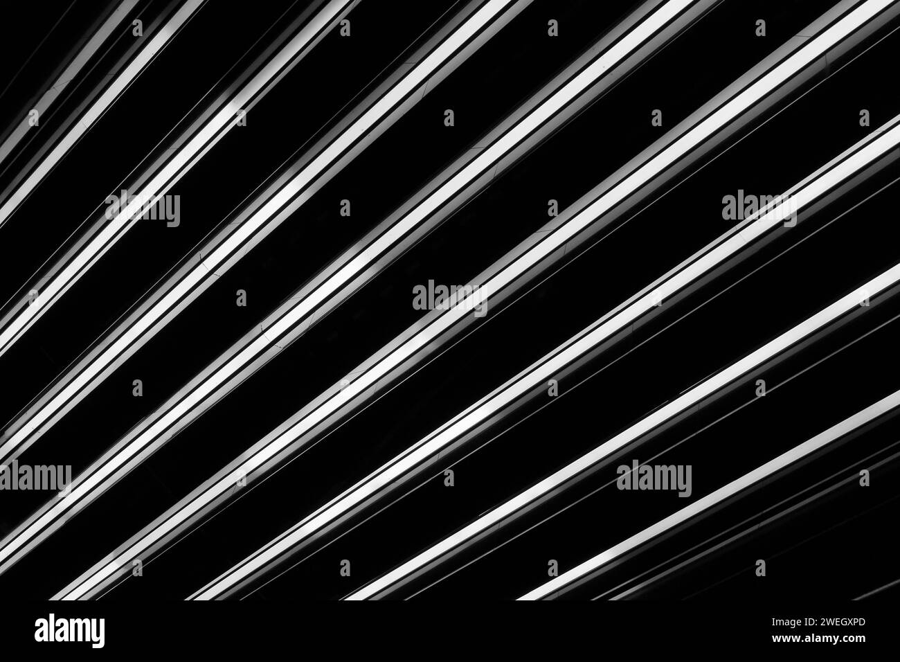 Black background with white diagonal stripes. Yellow ceiling light on ...