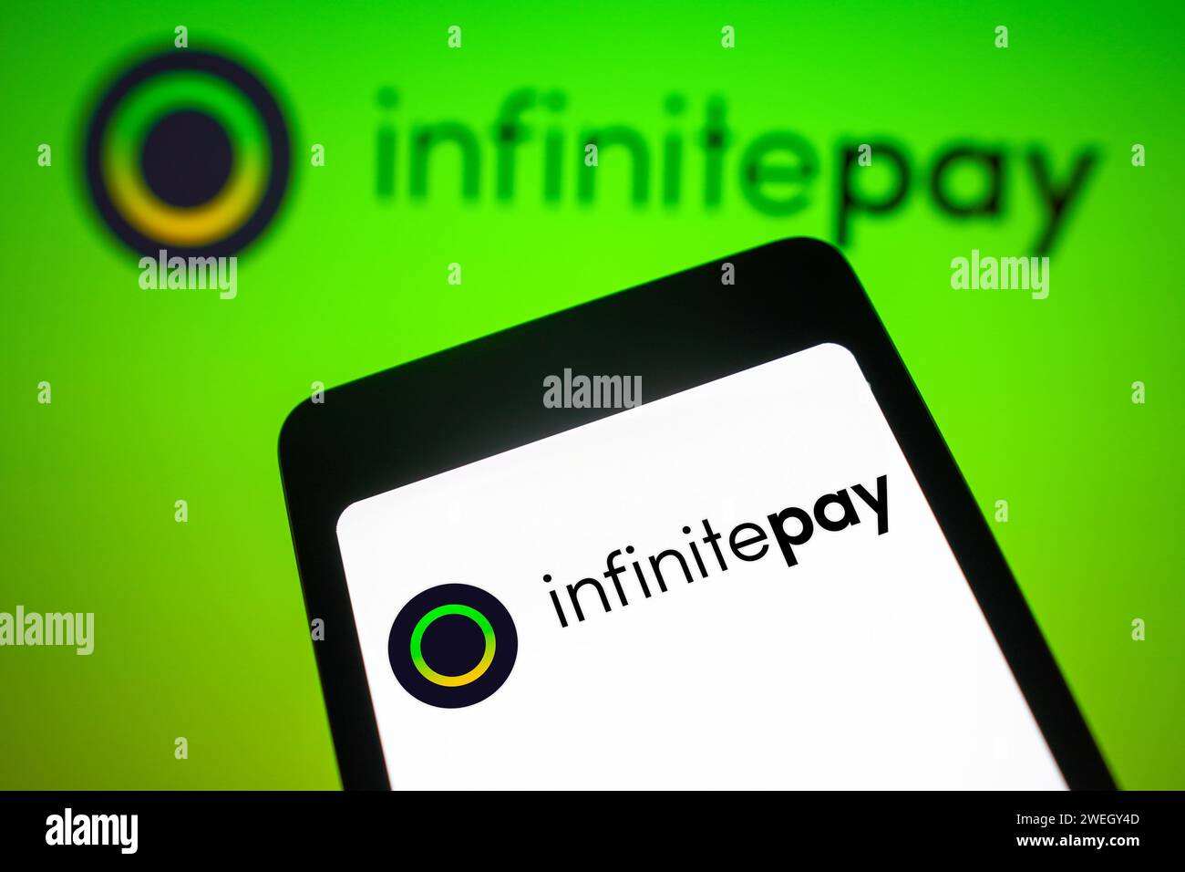 In this photo illustration, the InfinitePay logo is displayed on a smartphone screen and in the ...