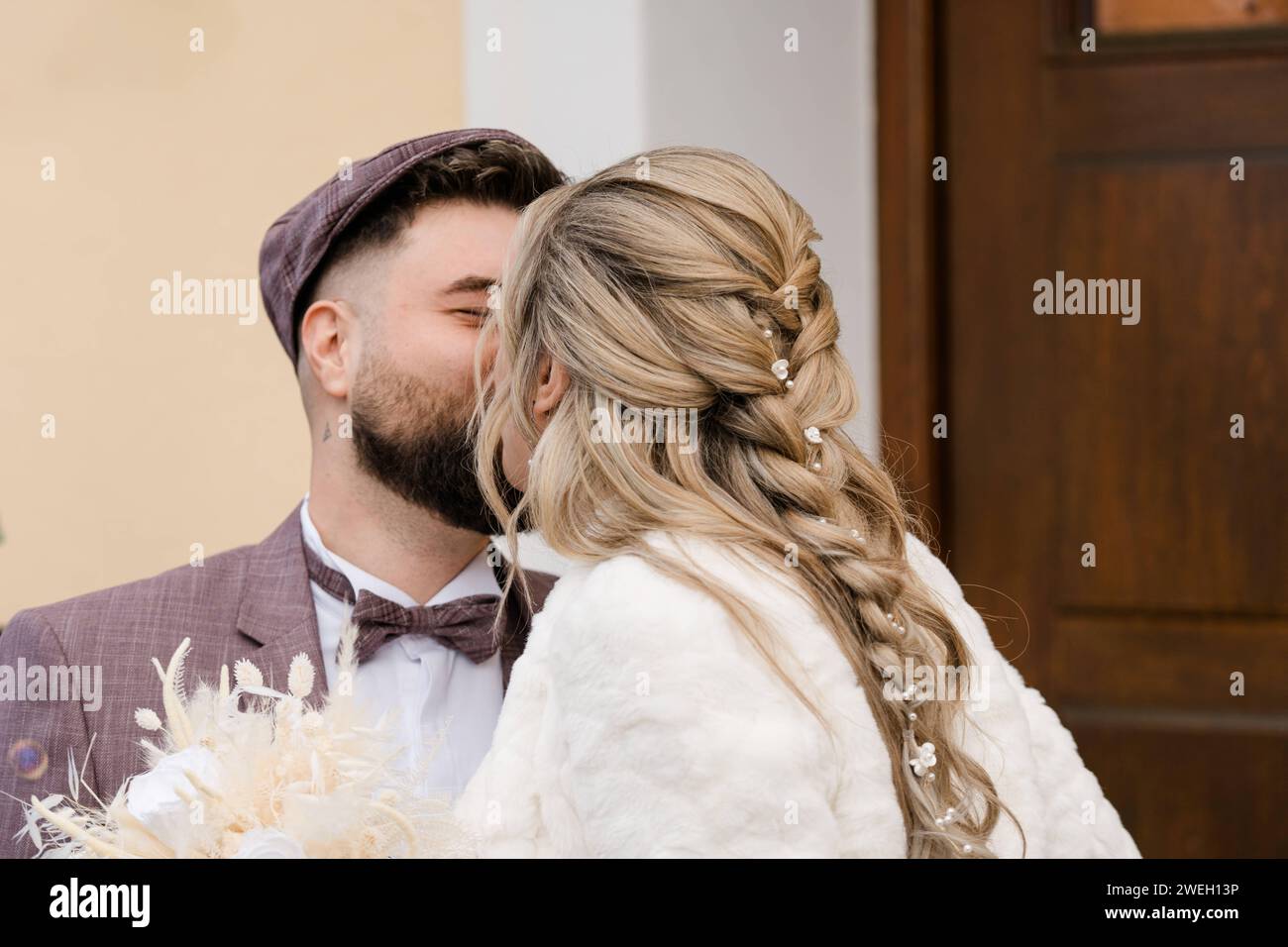 Bavaria, Germany - January 19, 2024: Young man and young woman kissing at their wedding ...