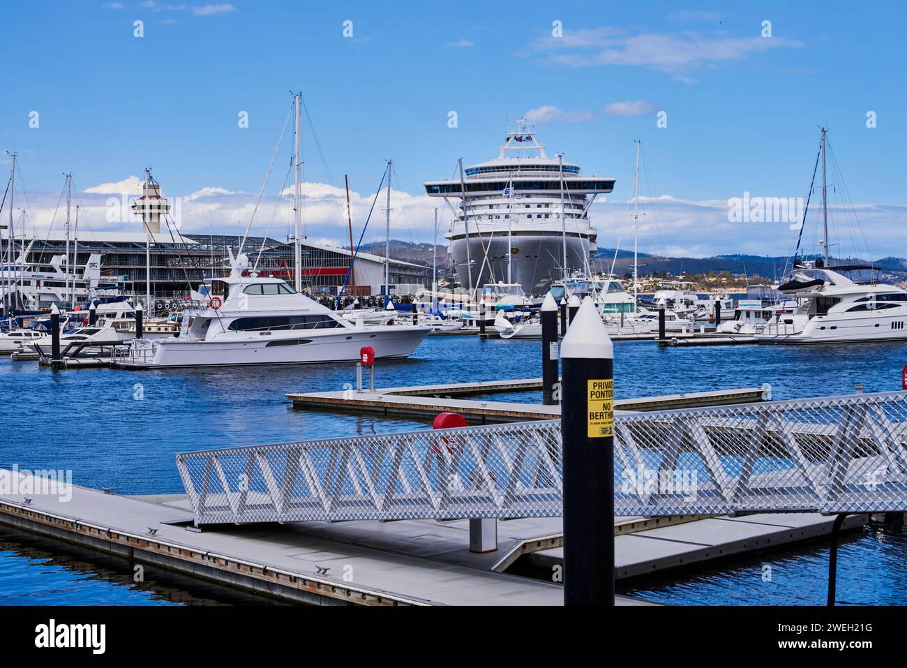 Several boats docked closely together on a serene body of water Stock ...
