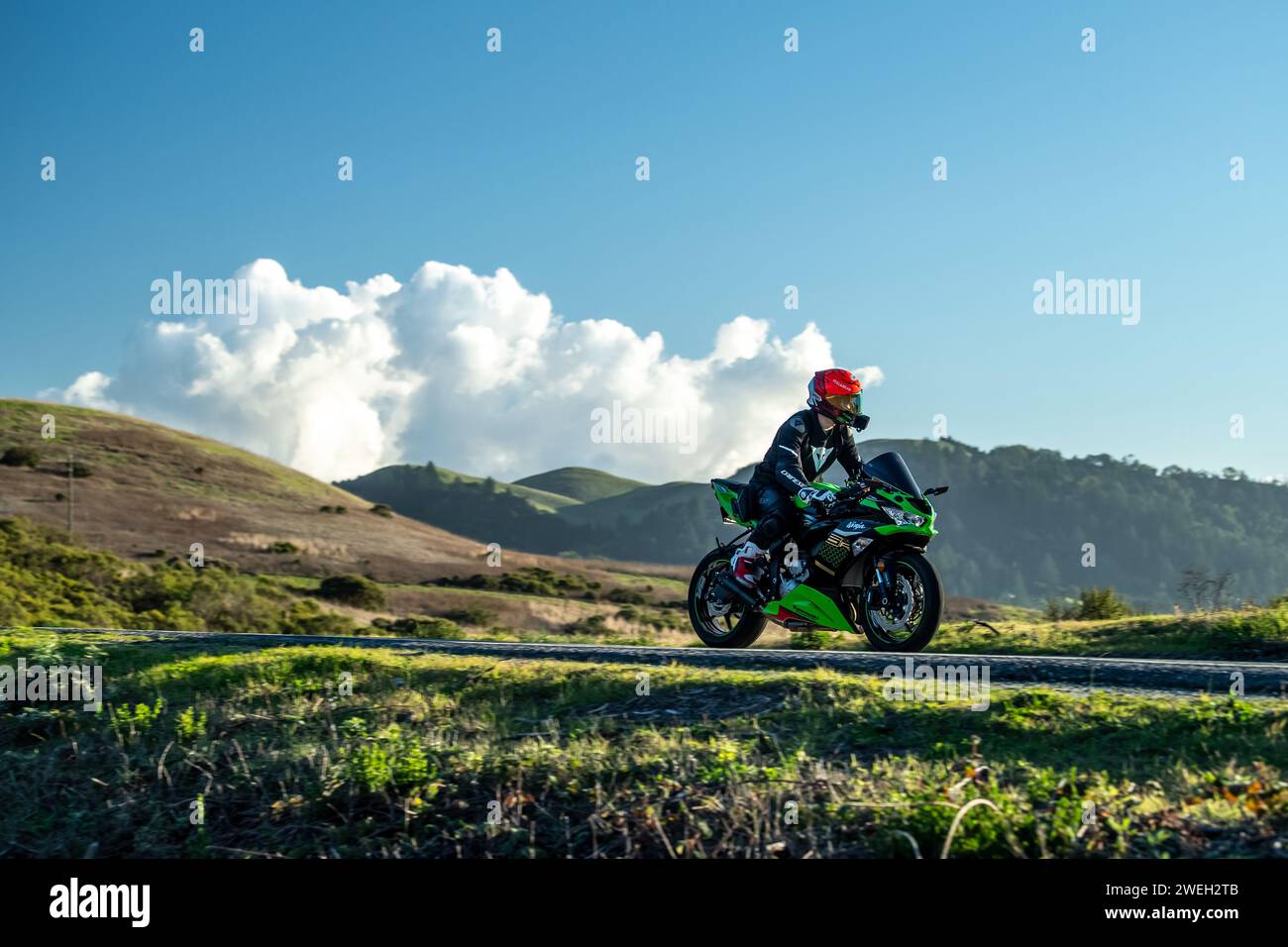 a Lone motorcycle riding along a mountain ridge with spectacular ...