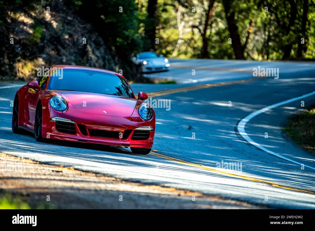 A Red Porsche coming towards the camera in a series of turns with ...
