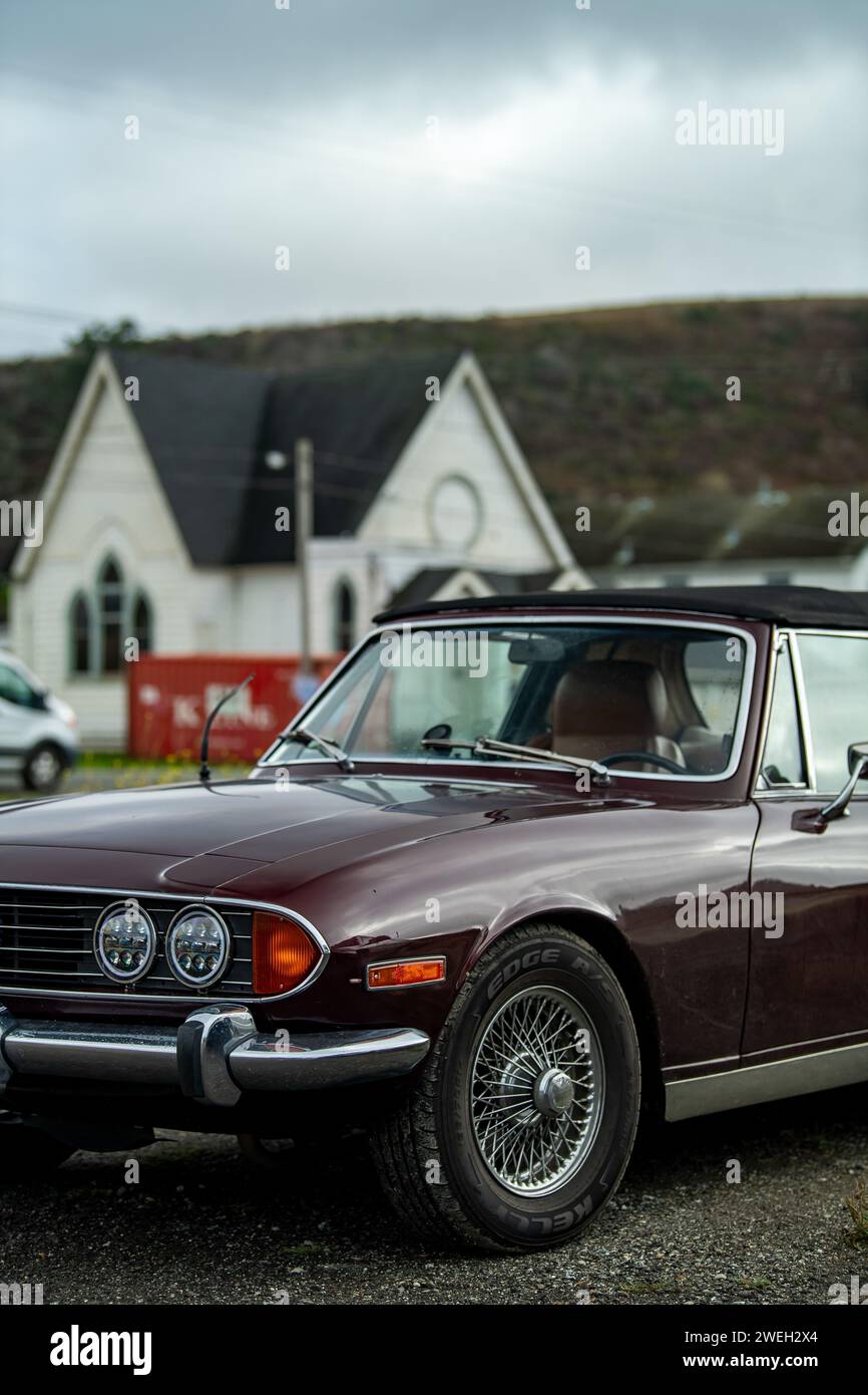 A Vintage Triumph car parked with old church in the background on a ...