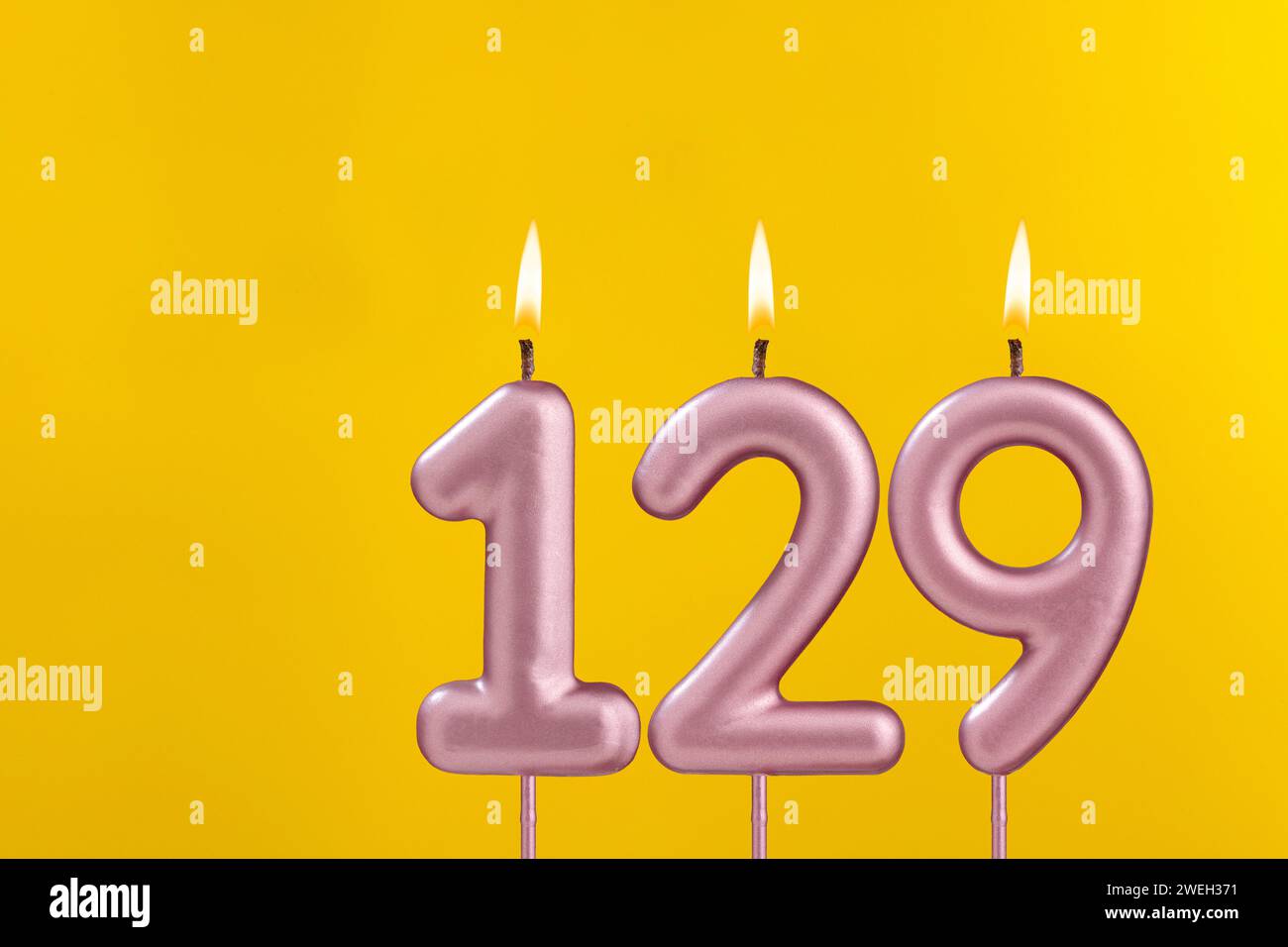 Birthday candle number 129 - Birthday celebration on yellow background ...