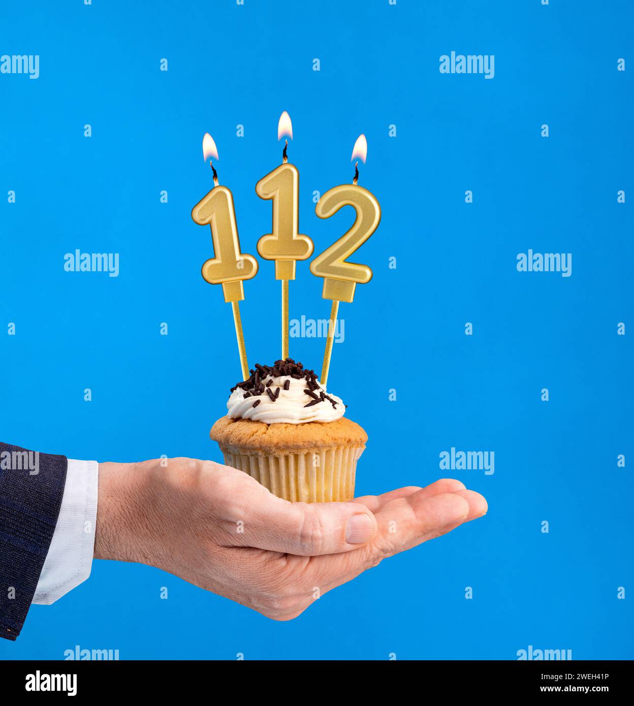 Hand delivering birthday cupcake - Candle number 112 on blue background ...