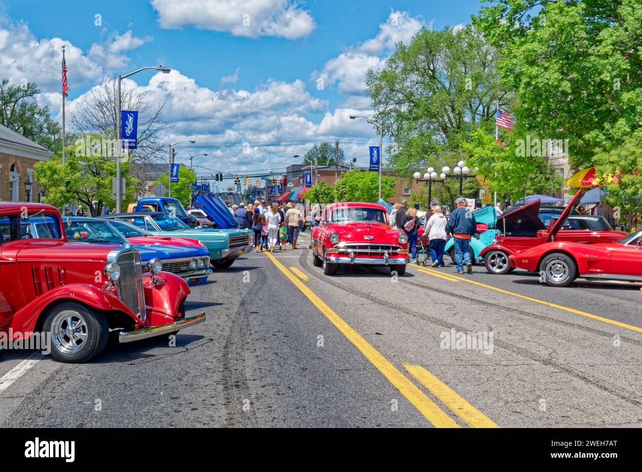 A variety of restored vintage automobiles lined up downtown main street ...