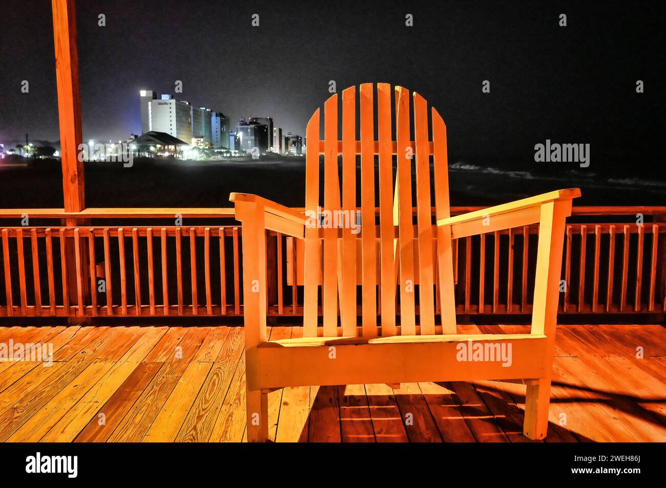 A chair on a deck with a city view at night Stock Photo - Alamy