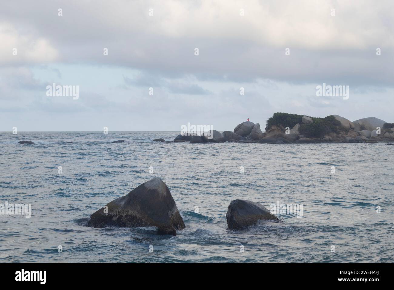 Beautiful caribbean sea blue landscape with big rocks and a man sitting ...