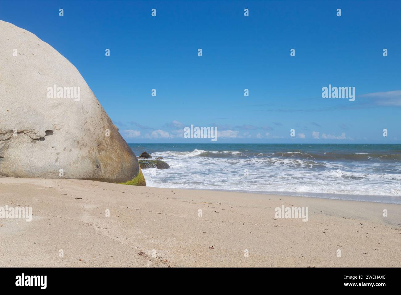 Beautiful caribbean beach scene with a big rock and blue sea with blue ...