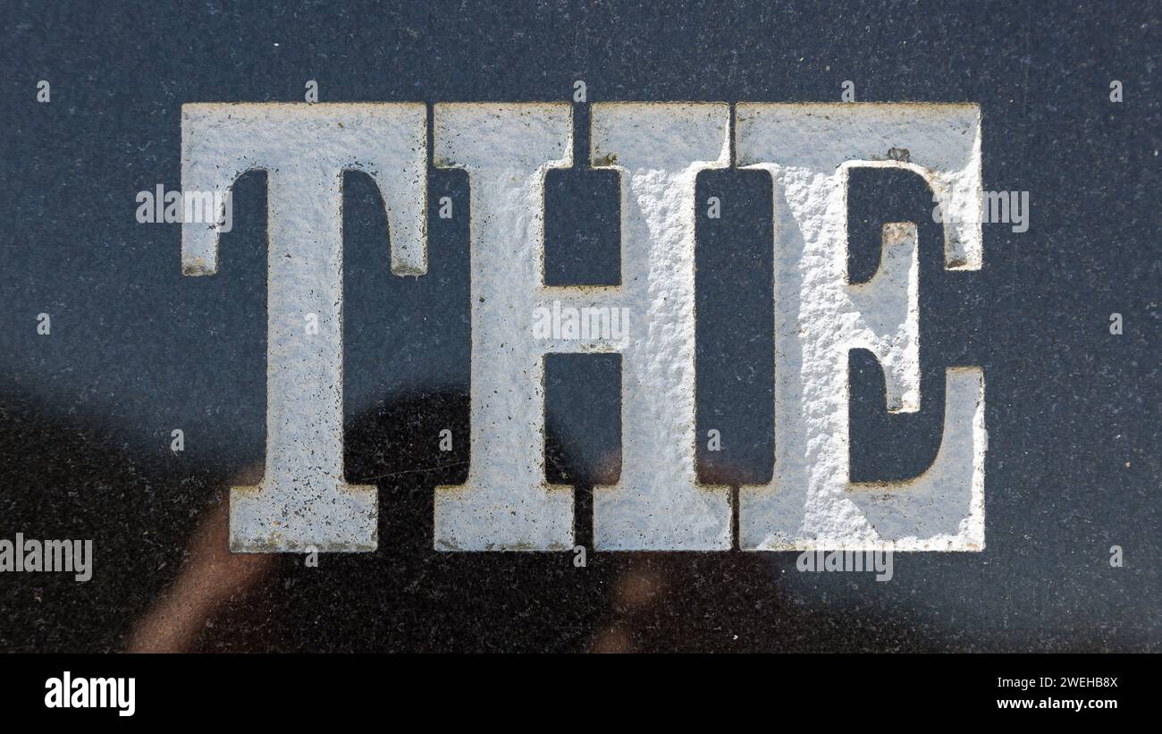 THE: Inscription THE on granite wall. White letters on black granite ...