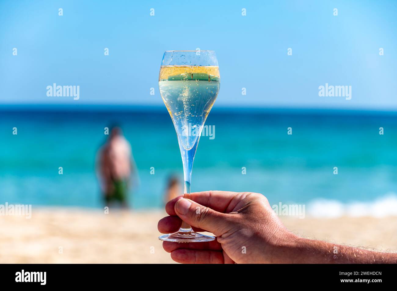 Hand with glass of cava or champagne sparkling wine on vacation, Dunes ...