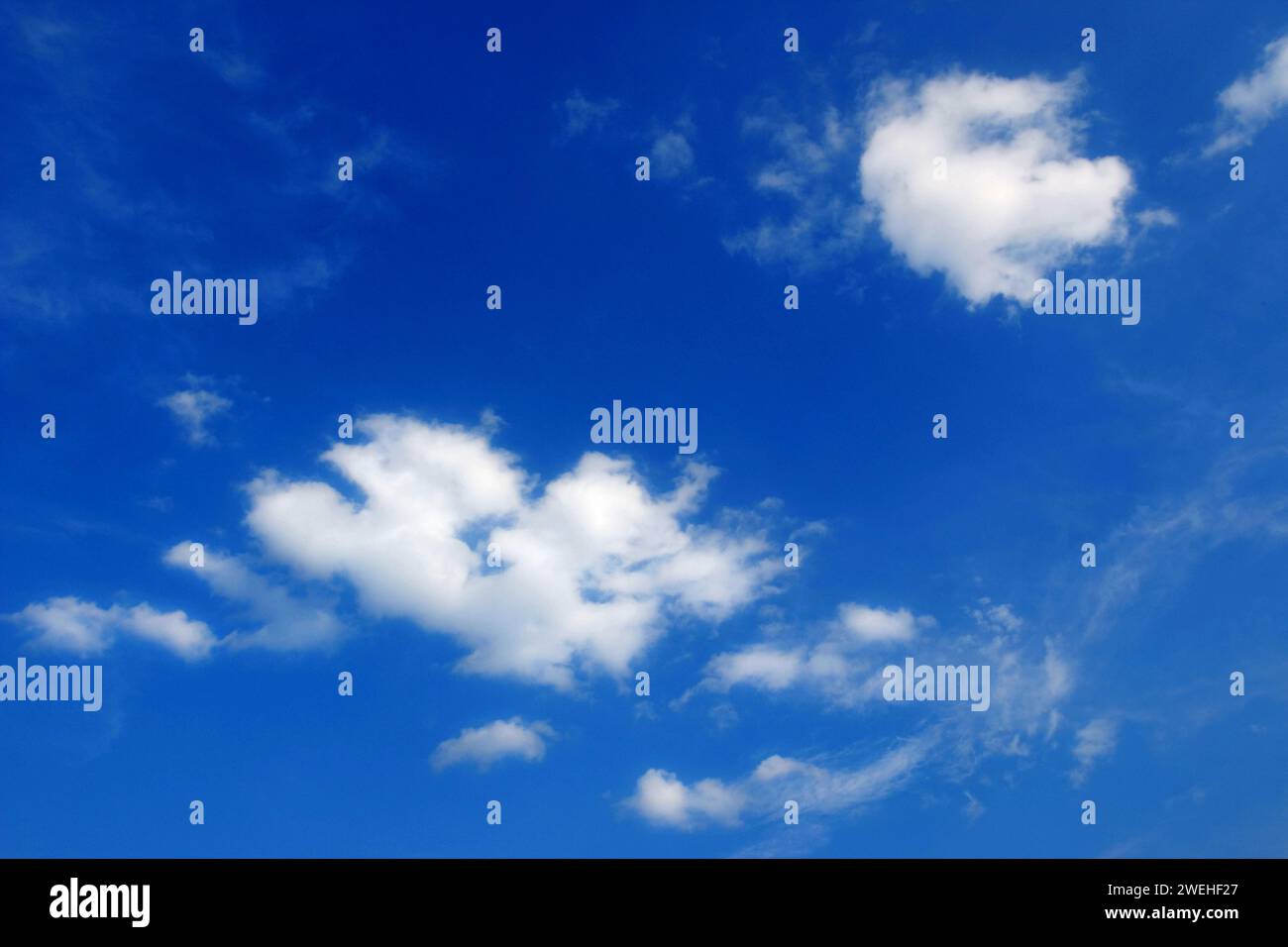 two white fair weather clouds, cumulus in the blue sky Stock Photo - Alamy