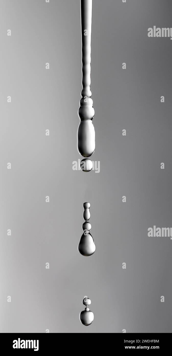 a thin stream of water from a sponge breaks off and begins to drip ...