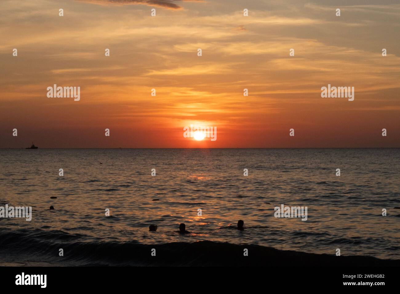 Amazing rounded orange sun sunset with clouds and caribbean sea line ...