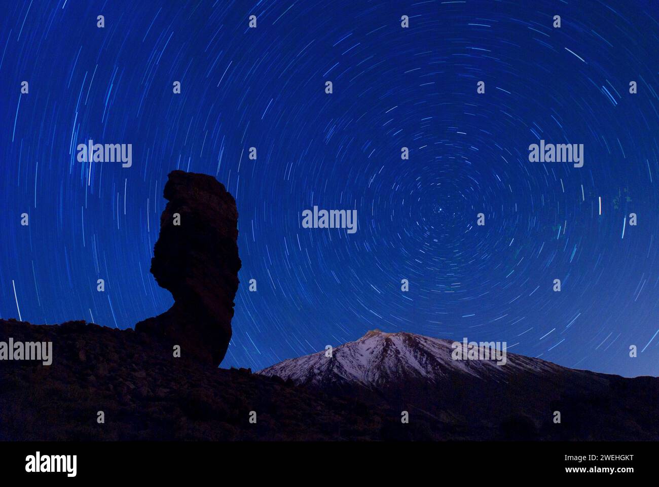 the Roque Cinchado at night with circling stars in the clear night sky ...