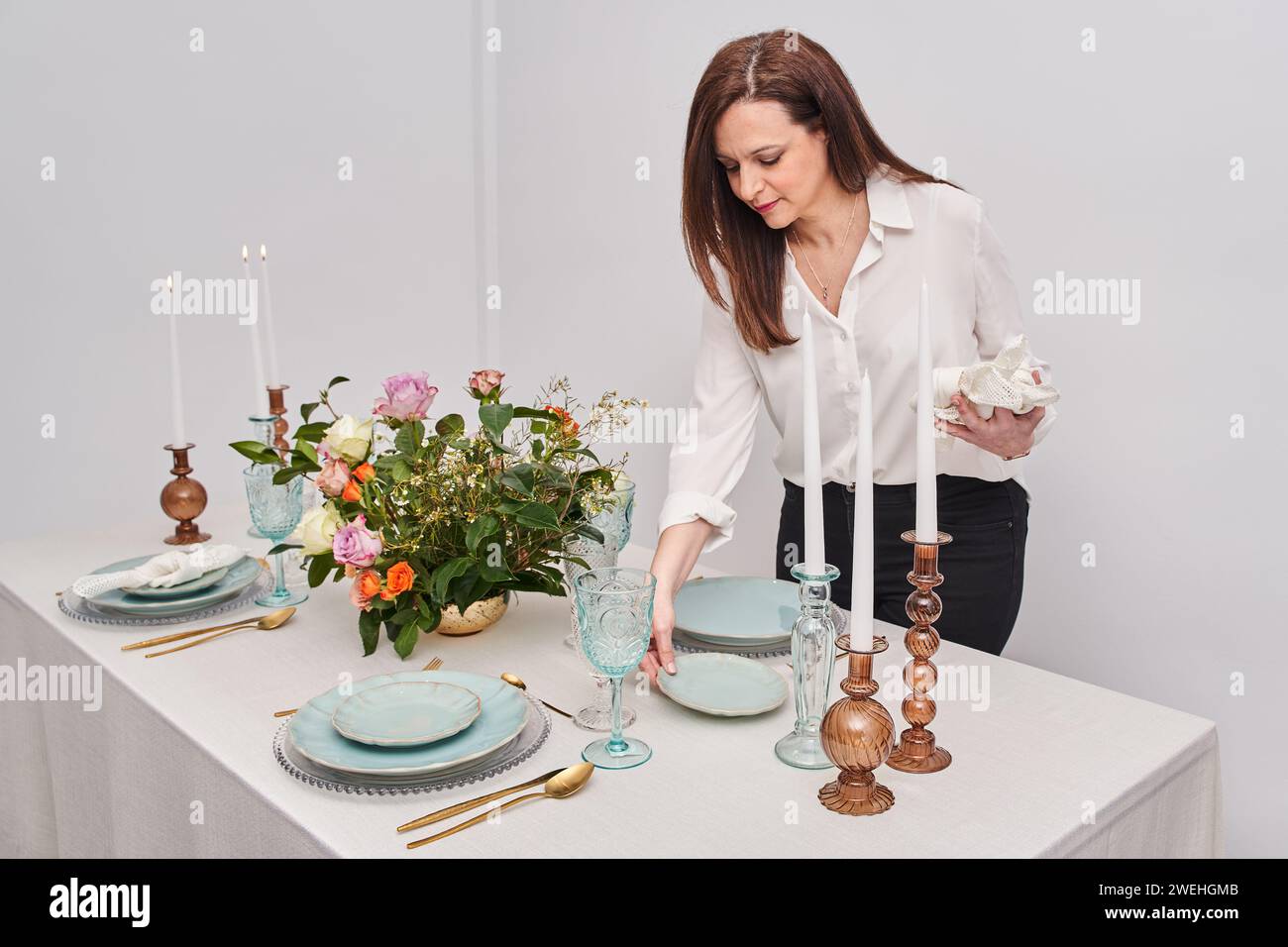 Beautiful woman laying table in kitchen at home Stock Photo - Alamy