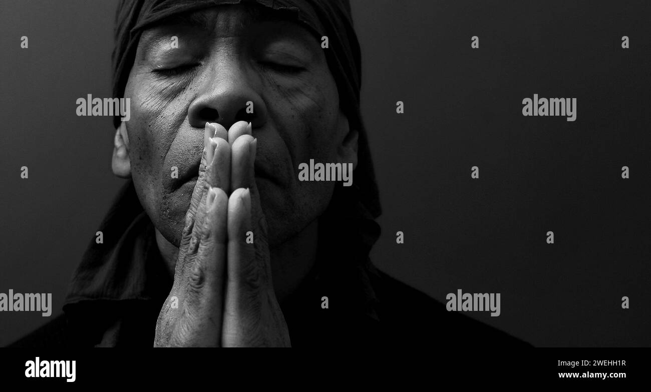 black man praying to god with hands together Caribbean man praying with ...