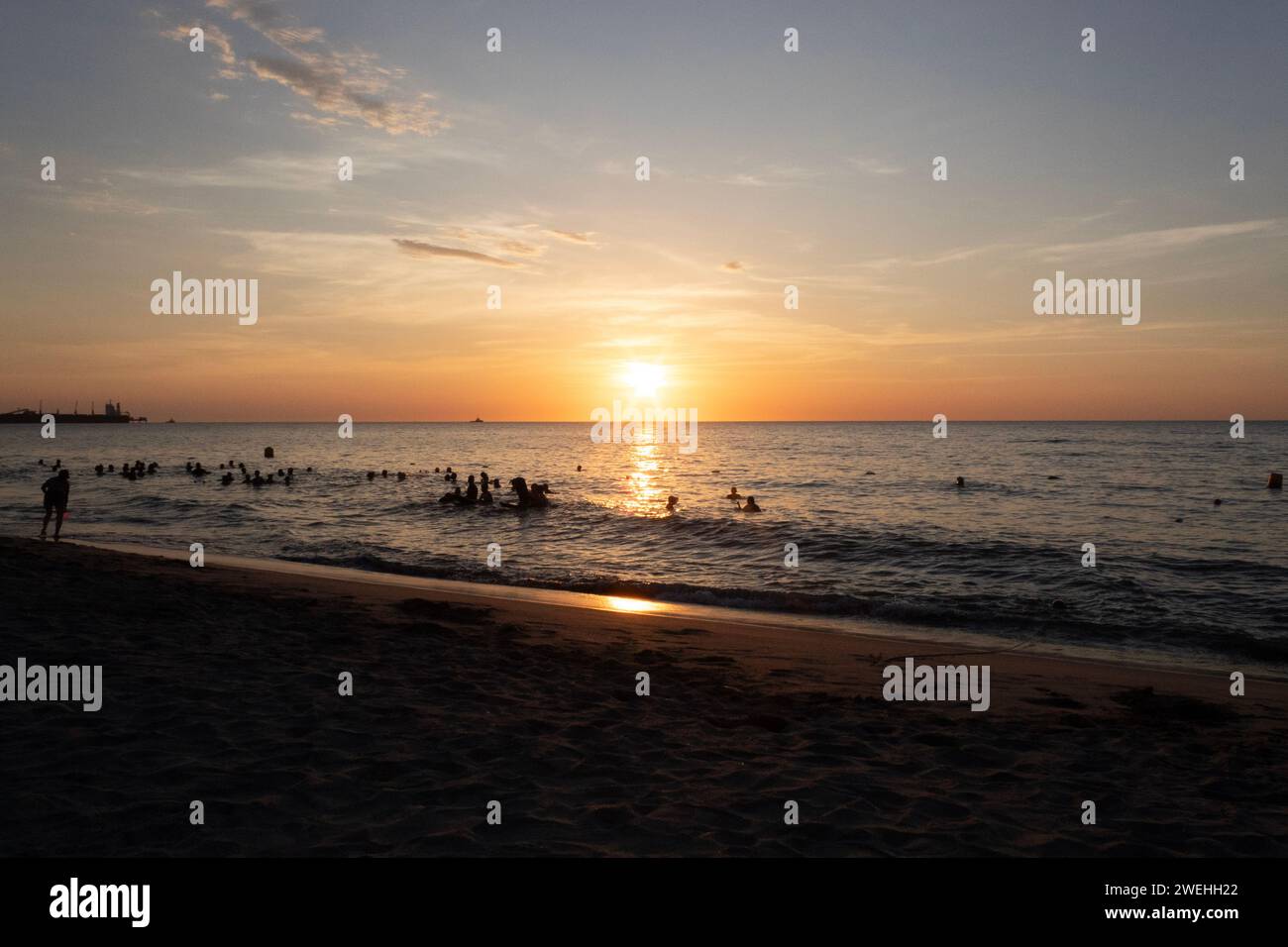 Tourist silhoette swimming and enjoying beach day sunset in colombian ...