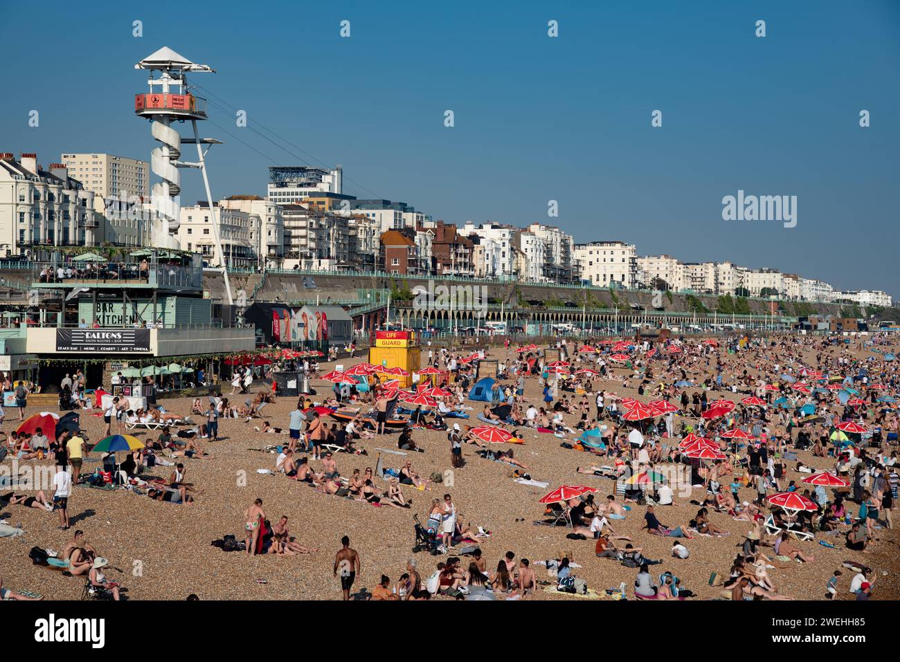 Crowd of British people sunbathing swimming and relaxing in the beach ...