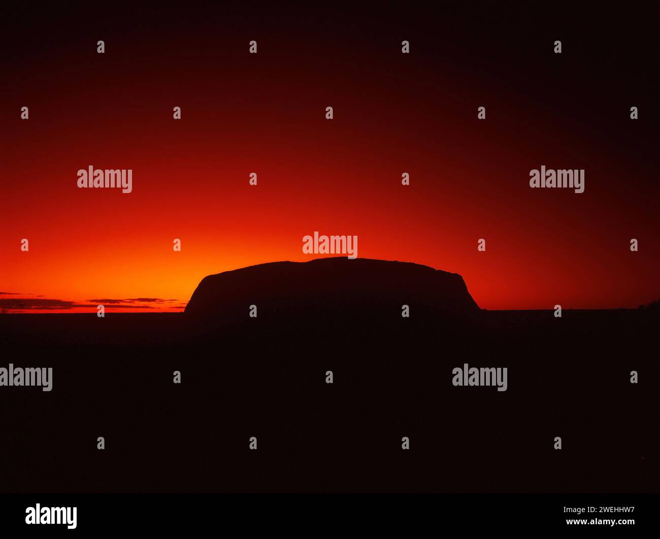 Silhouette outline of Ayers Rock or Uluru in red sunrise or sunset ...