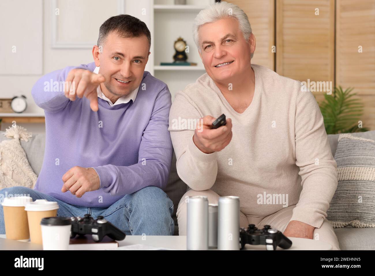 Mature brothers watching TV at home Stock Photo - Alamy