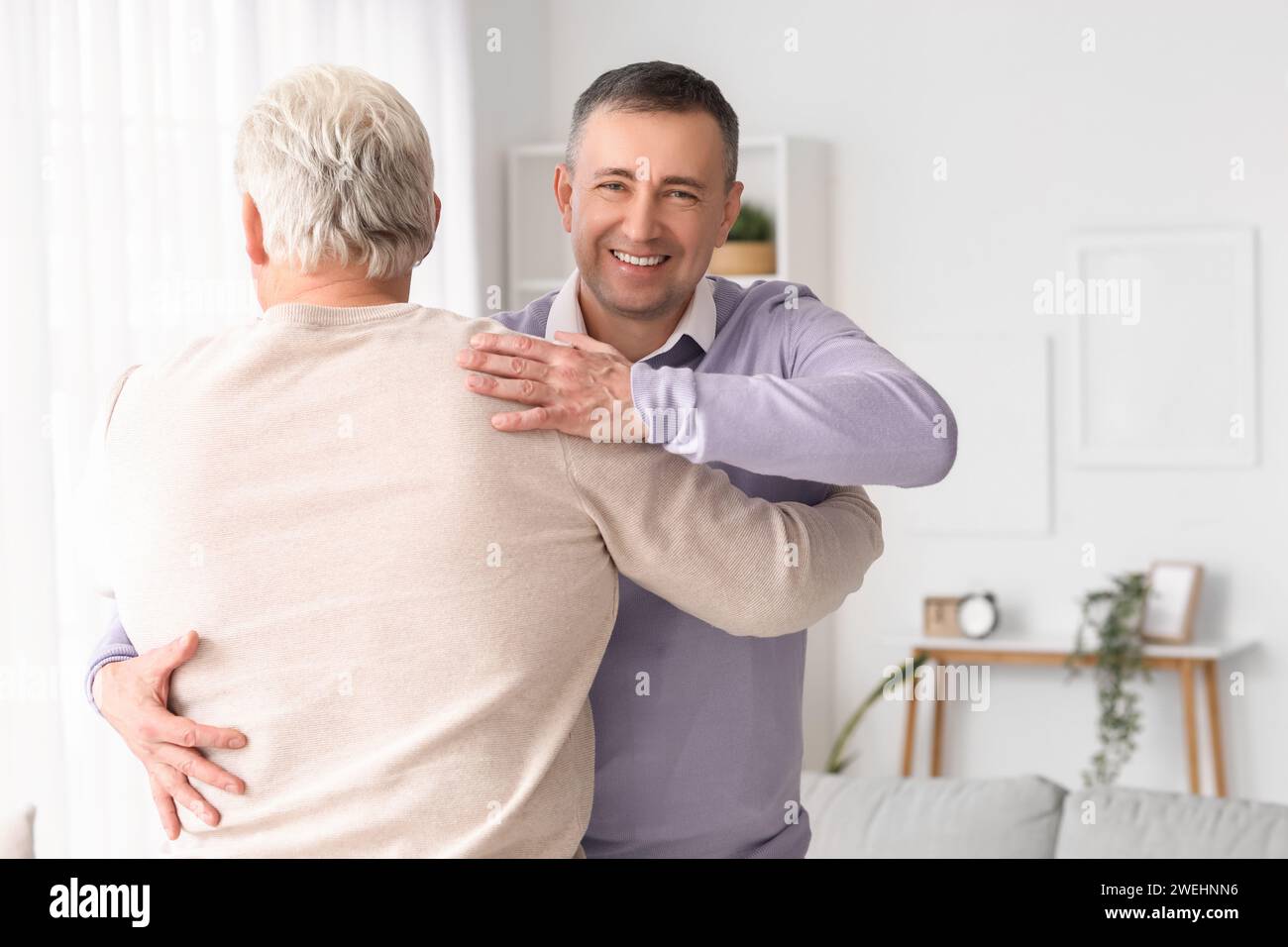 Mature brothers hugging at home Stock Photo - Alamy