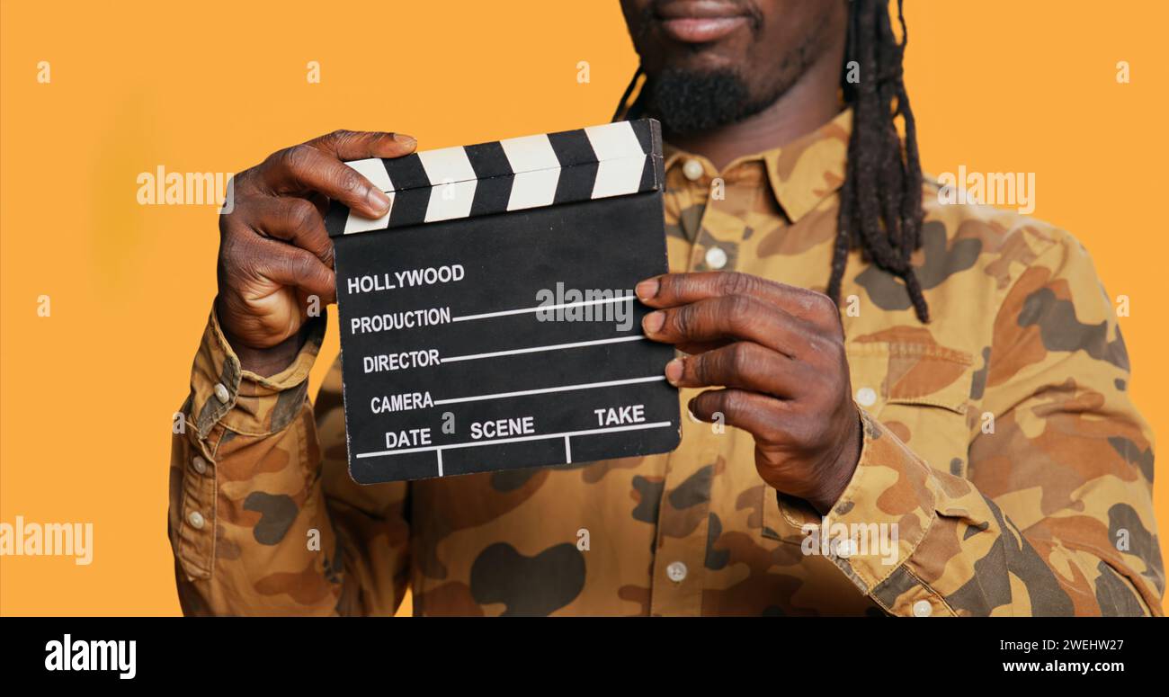 African american film producer using clapperboard for movie industry ...