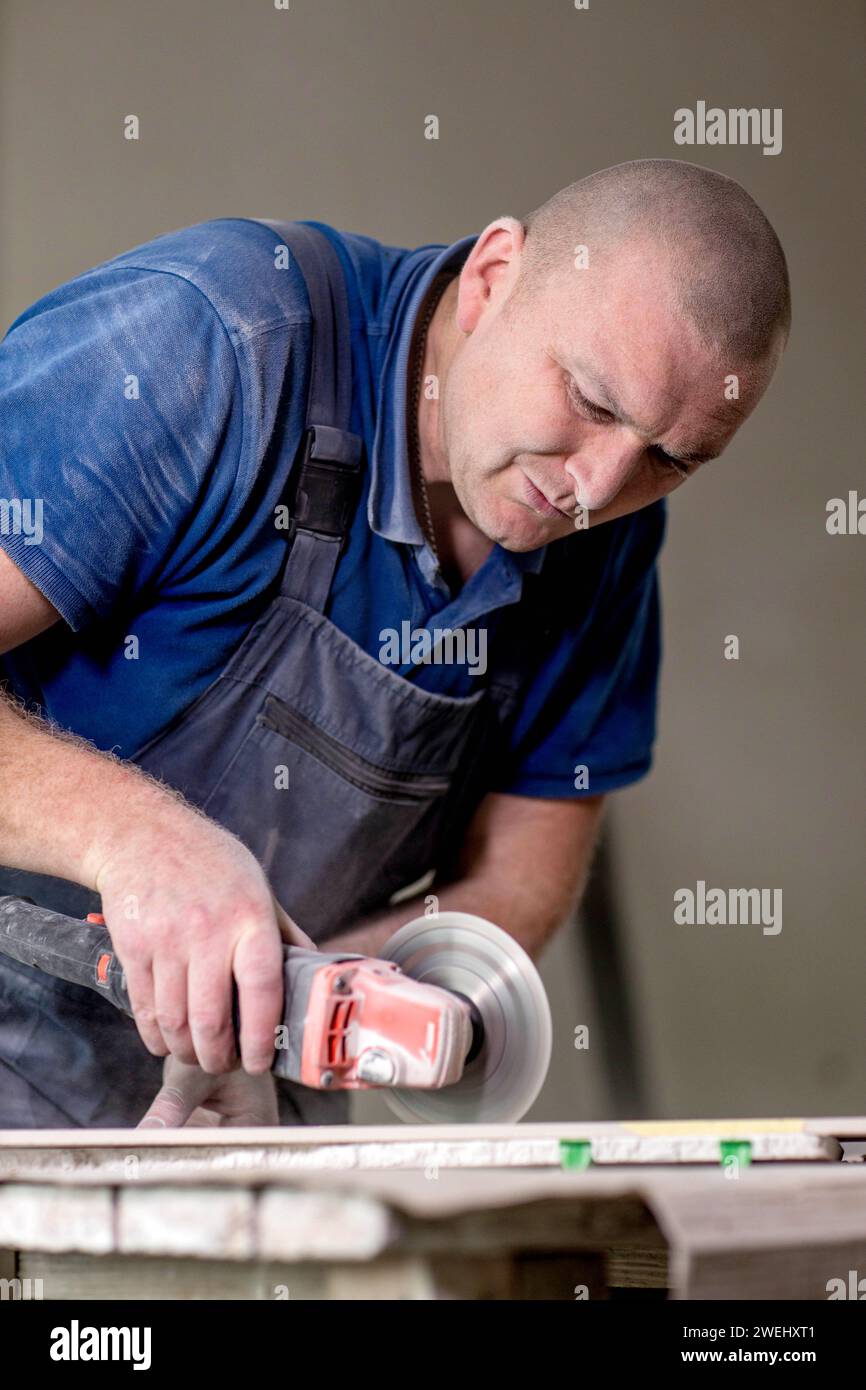 Professional tiler cutting ceramic tile for the floor or wall. Flooring ...