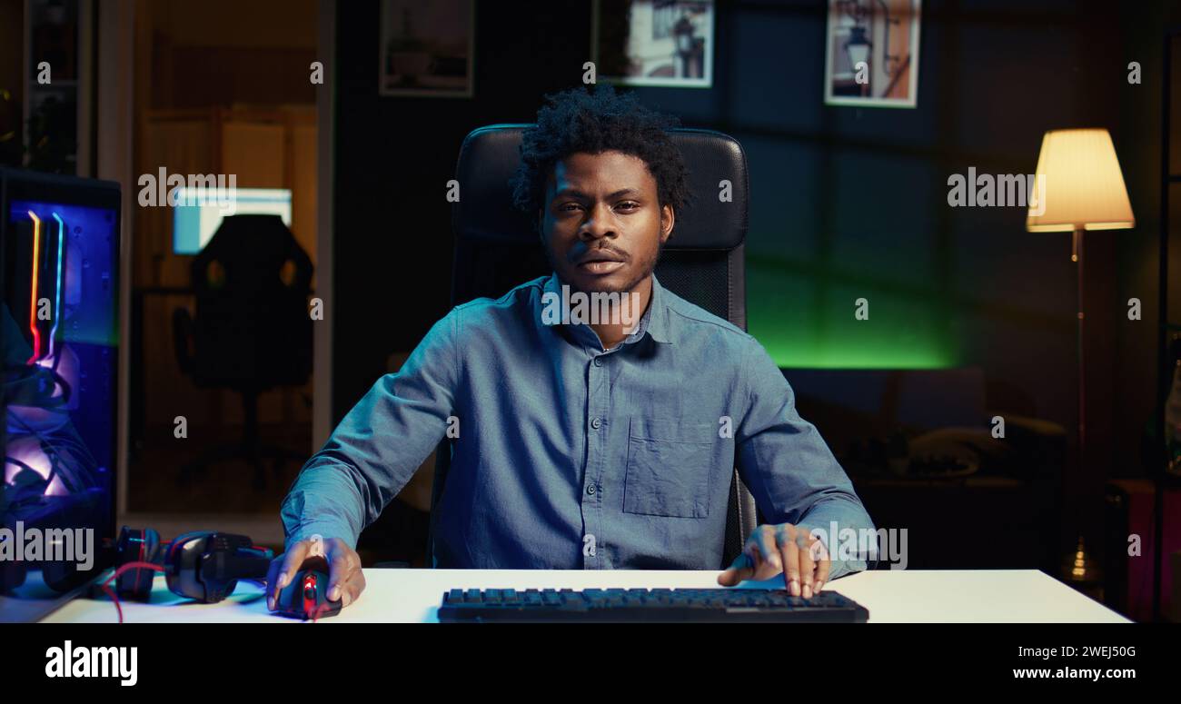 Man playing intense game on rgb lit computer desktop, spamming mouse ...