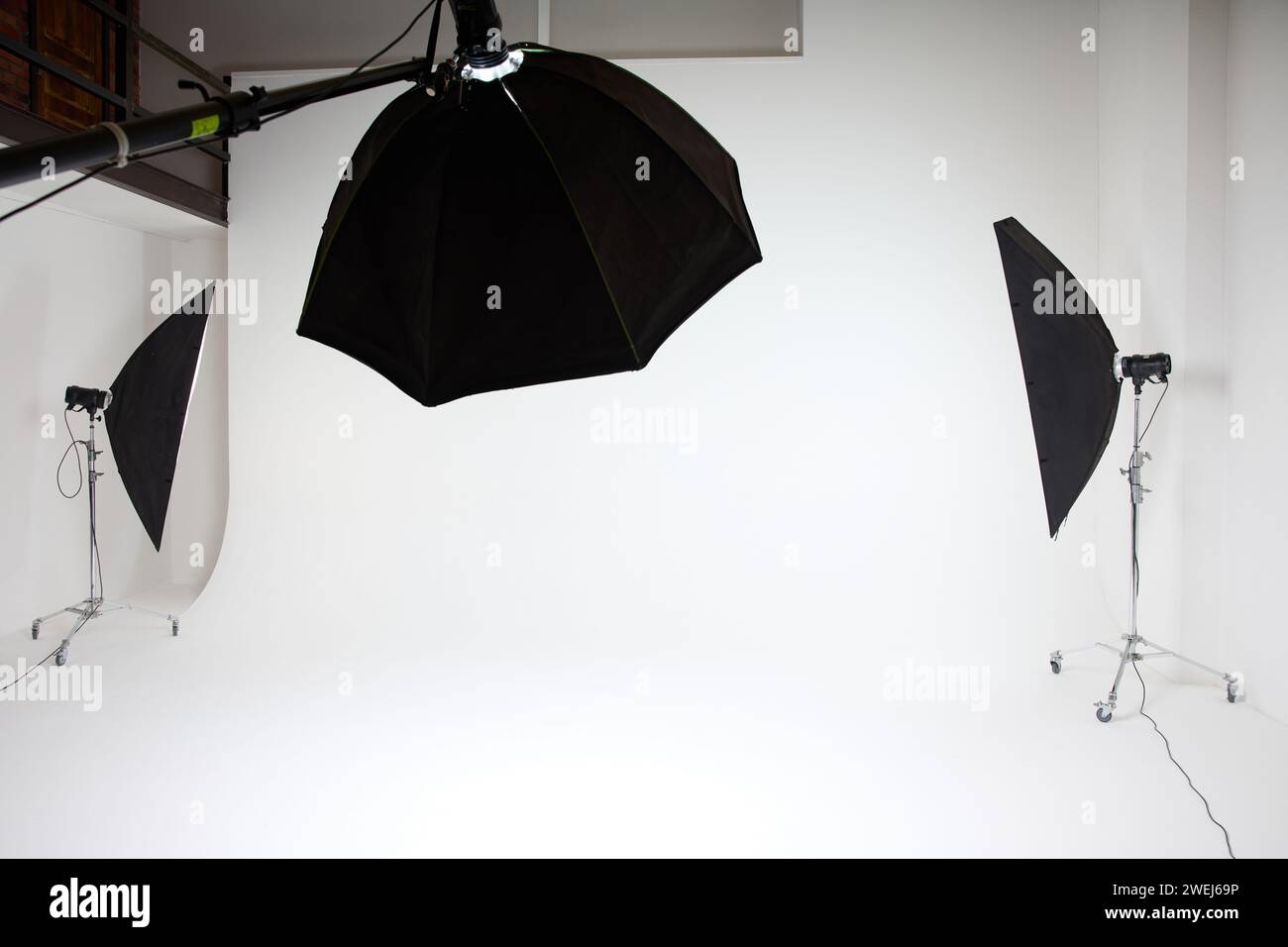 photo studio inside, white background, several racks with light sources ...