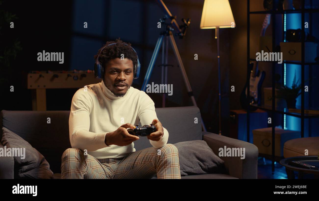 African american man in living room playing video games on gaming ...