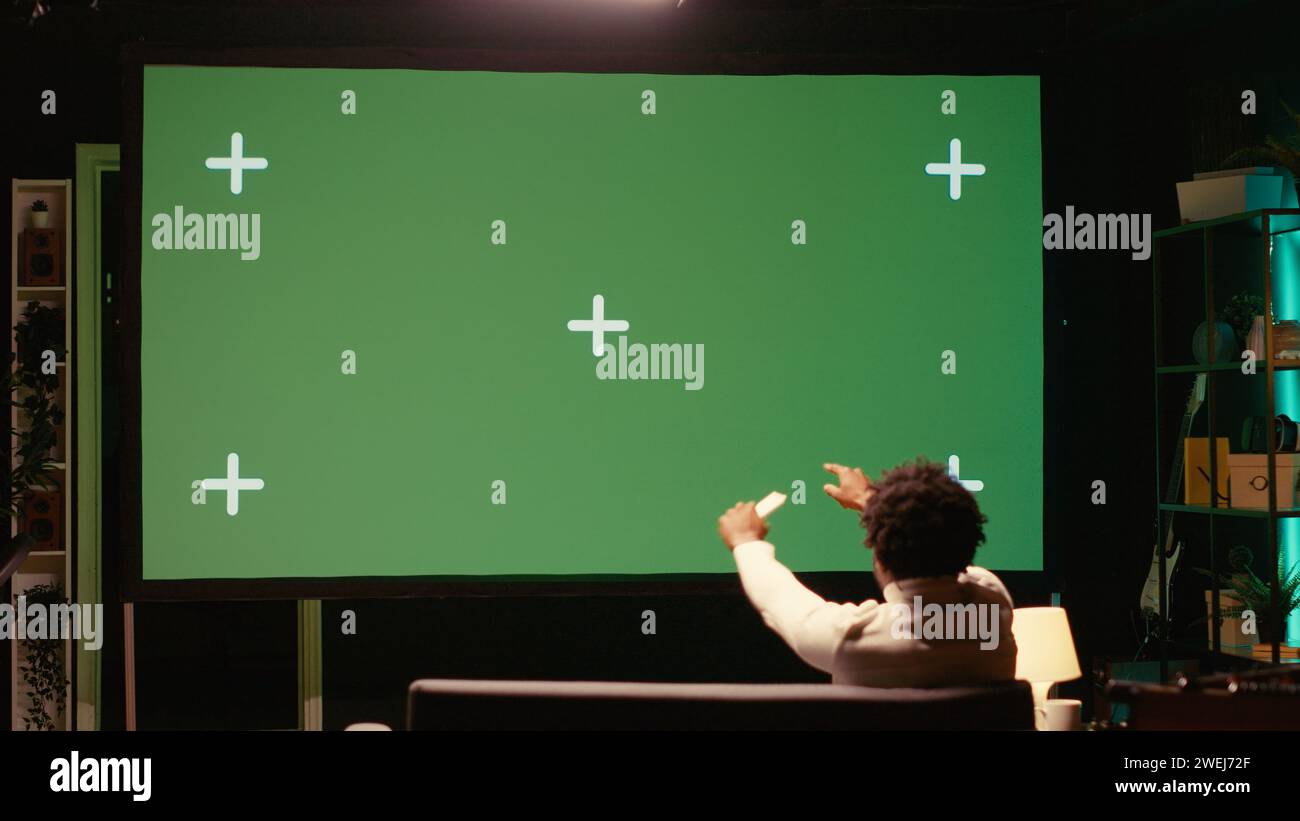 African american man watching football competition live on widescreen ...