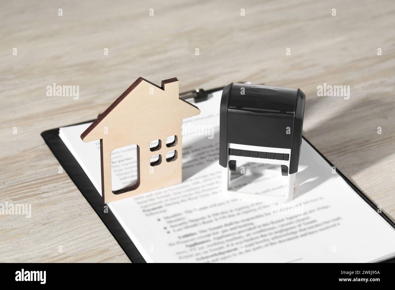 Notary contract. Stamp, figure of house and documents on wooden table ...