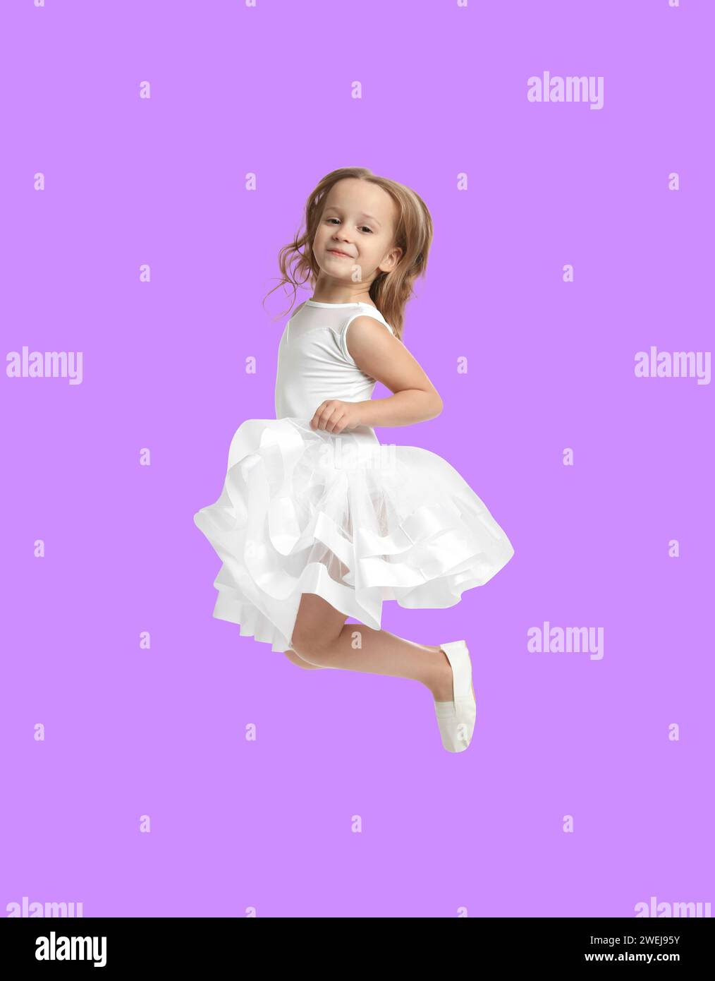 Happy cute girl jumping on violet background Stock Photo - Alamy