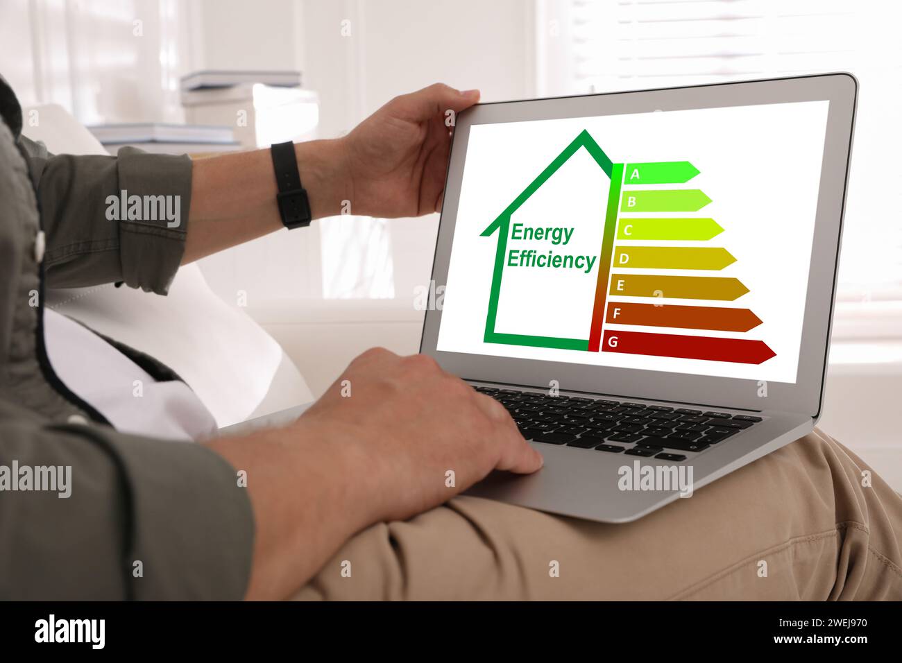 Energy efficiency. Man using laptop with colorful rating on display at ...