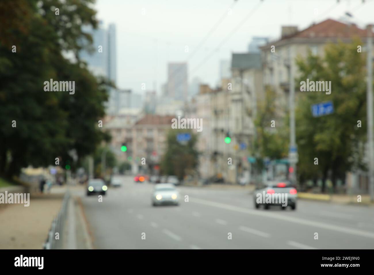 Blurred view of quiet street with beautiful buildings, road and trees ...