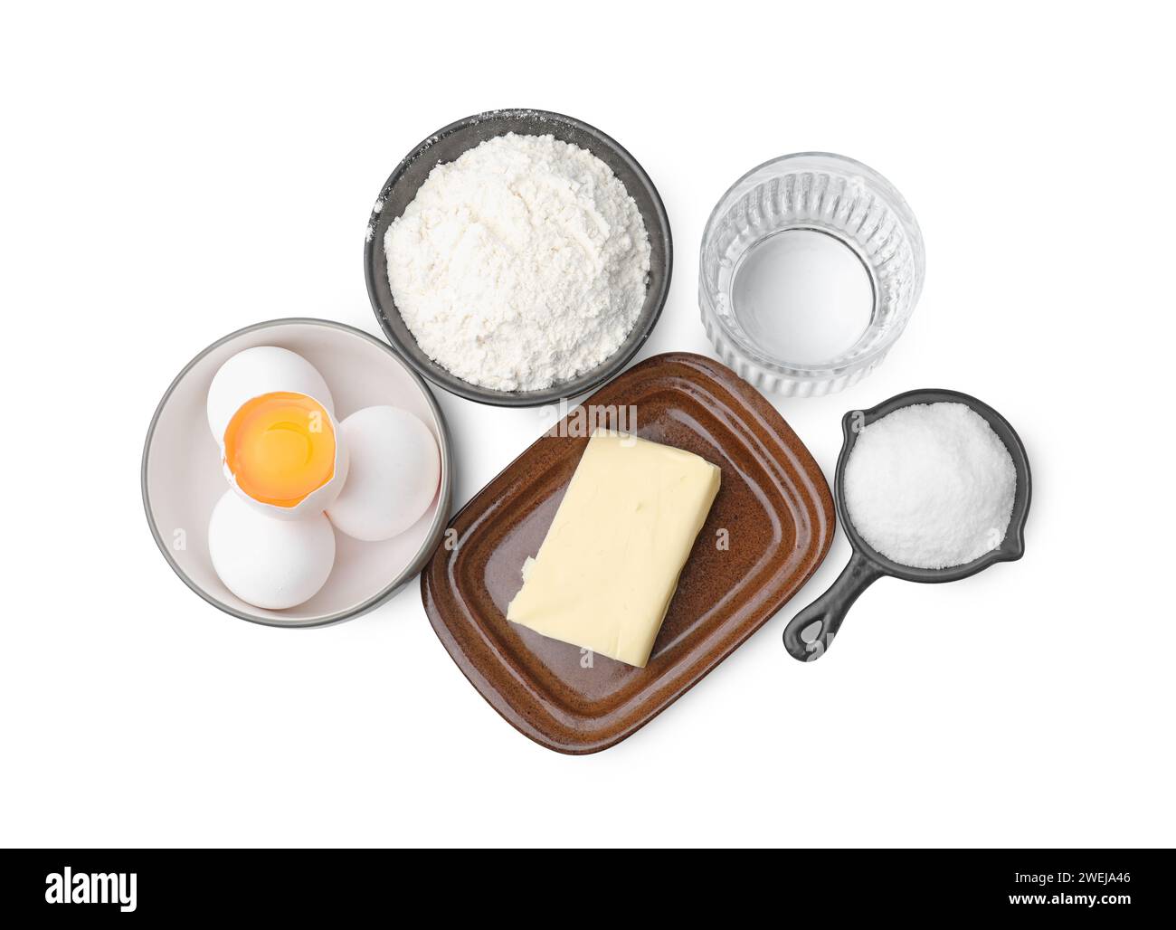 Eggs, butter, flour, salt and water isolated on white, top view ...