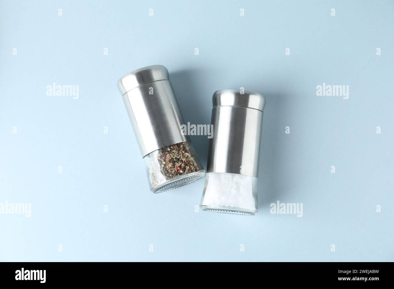 Salt and pepper shakers on light background, top view Stock Photo - Alamy