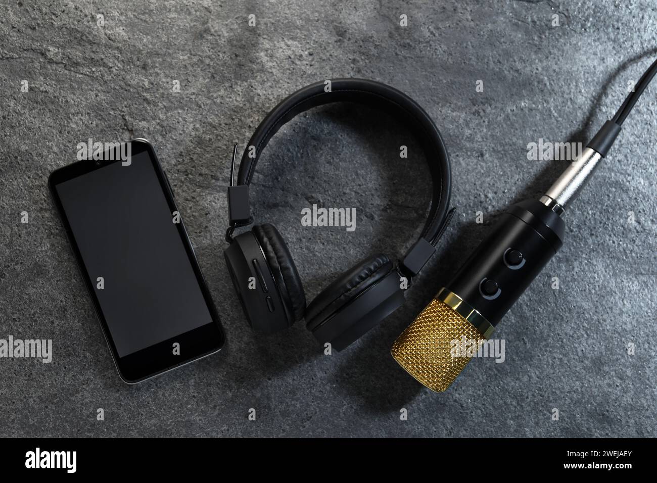 Smartphone with blank screen, headphones and microphone on grey ...
