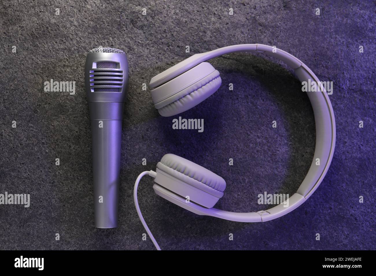 Microphone and headphones on grey textured background, flat lay. Sound ...