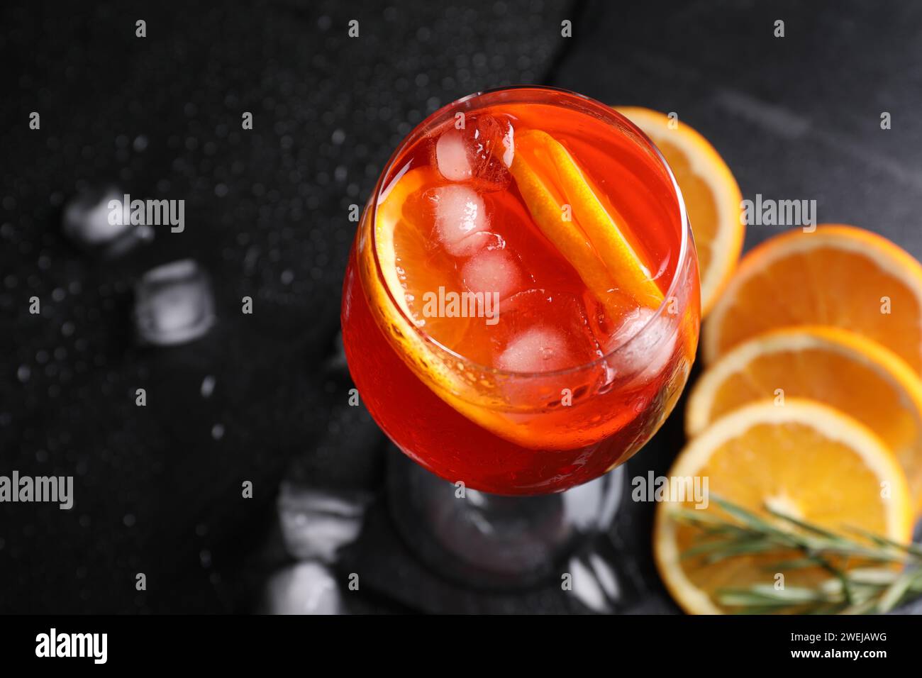 Glass of tasty Aperol spritz cocktail with orange slices and ice cubes ...