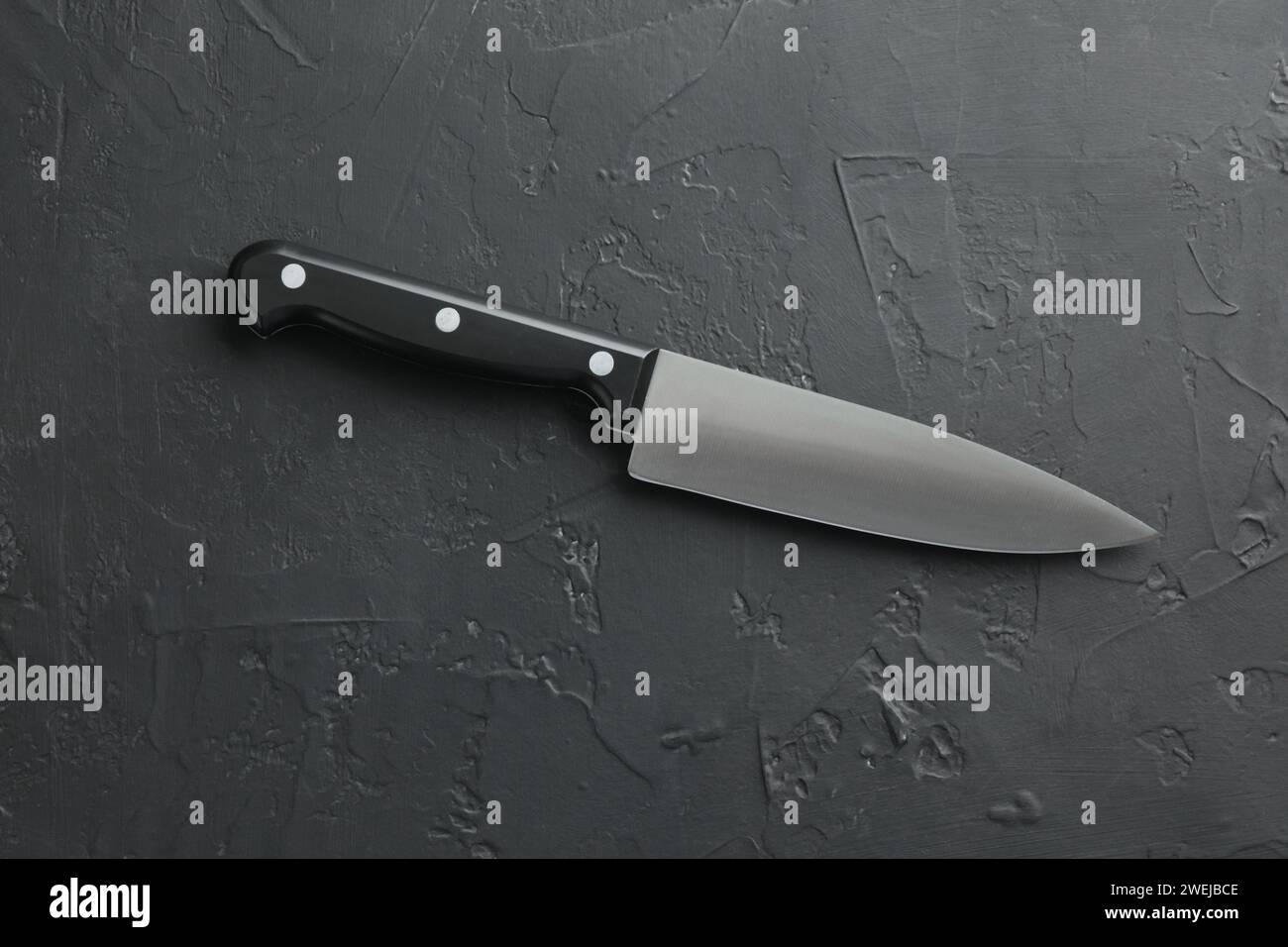 One sharp knife on dark textured table, top view Stock Photo - Alamy