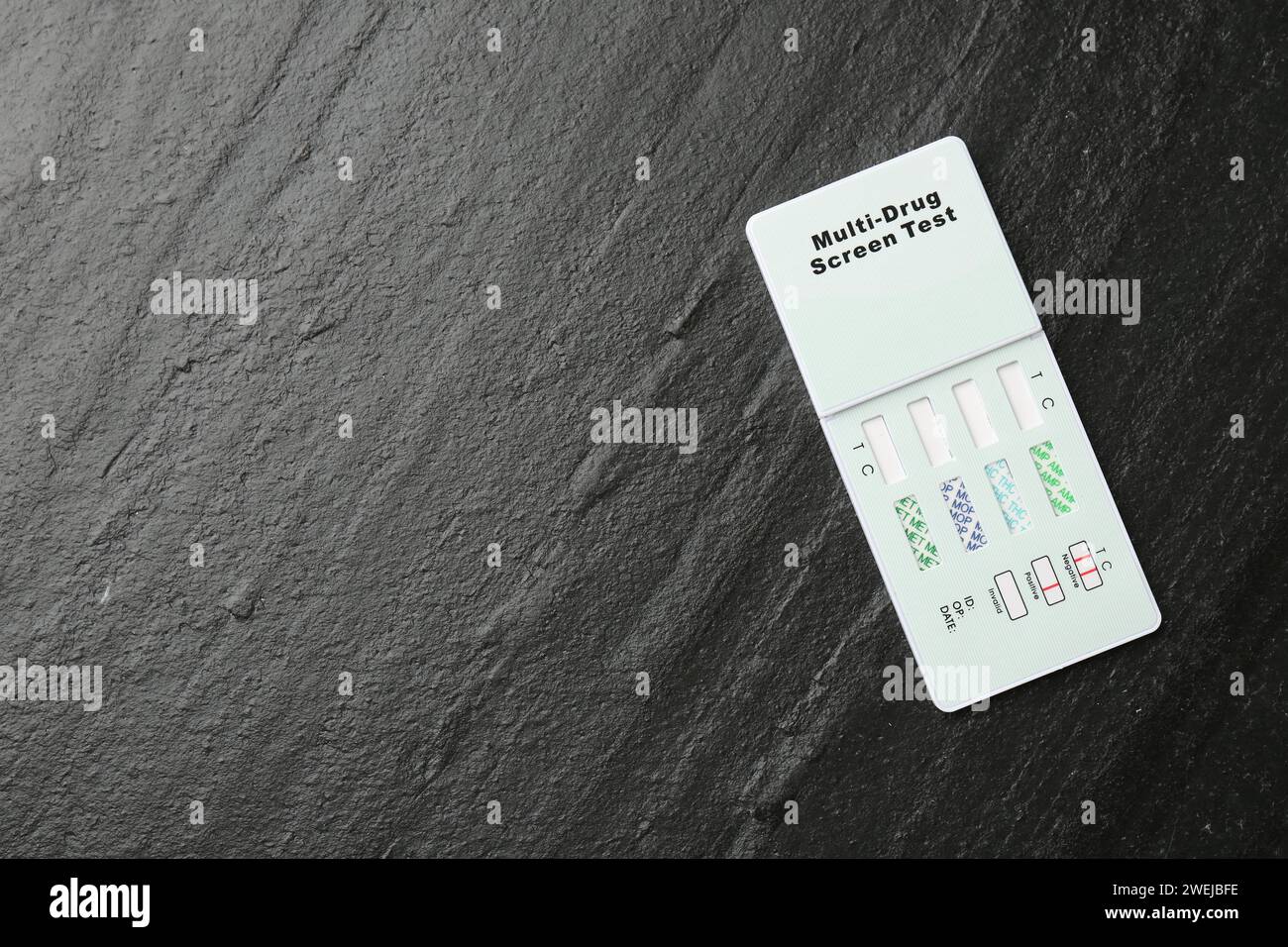 Multi-drug screen test on black textured table, top view. Space for ...