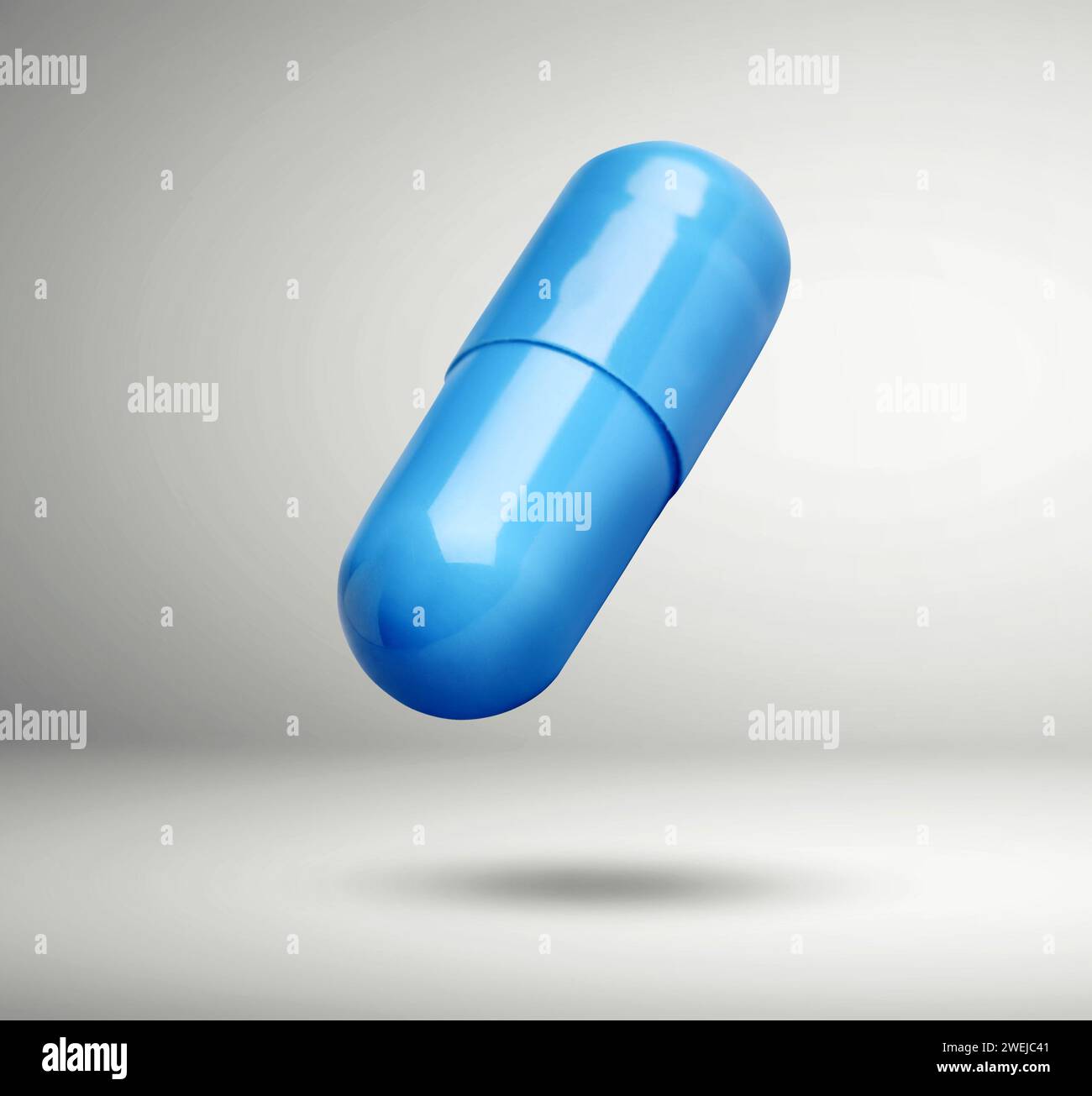 Light blue vitamin capsule in air on light grey background Stock Photo ...