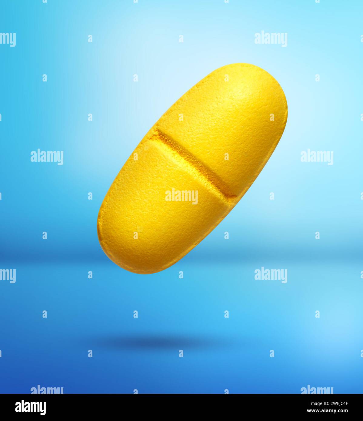 Yellow vitamin pill in air on light blue gradient background Stock ...