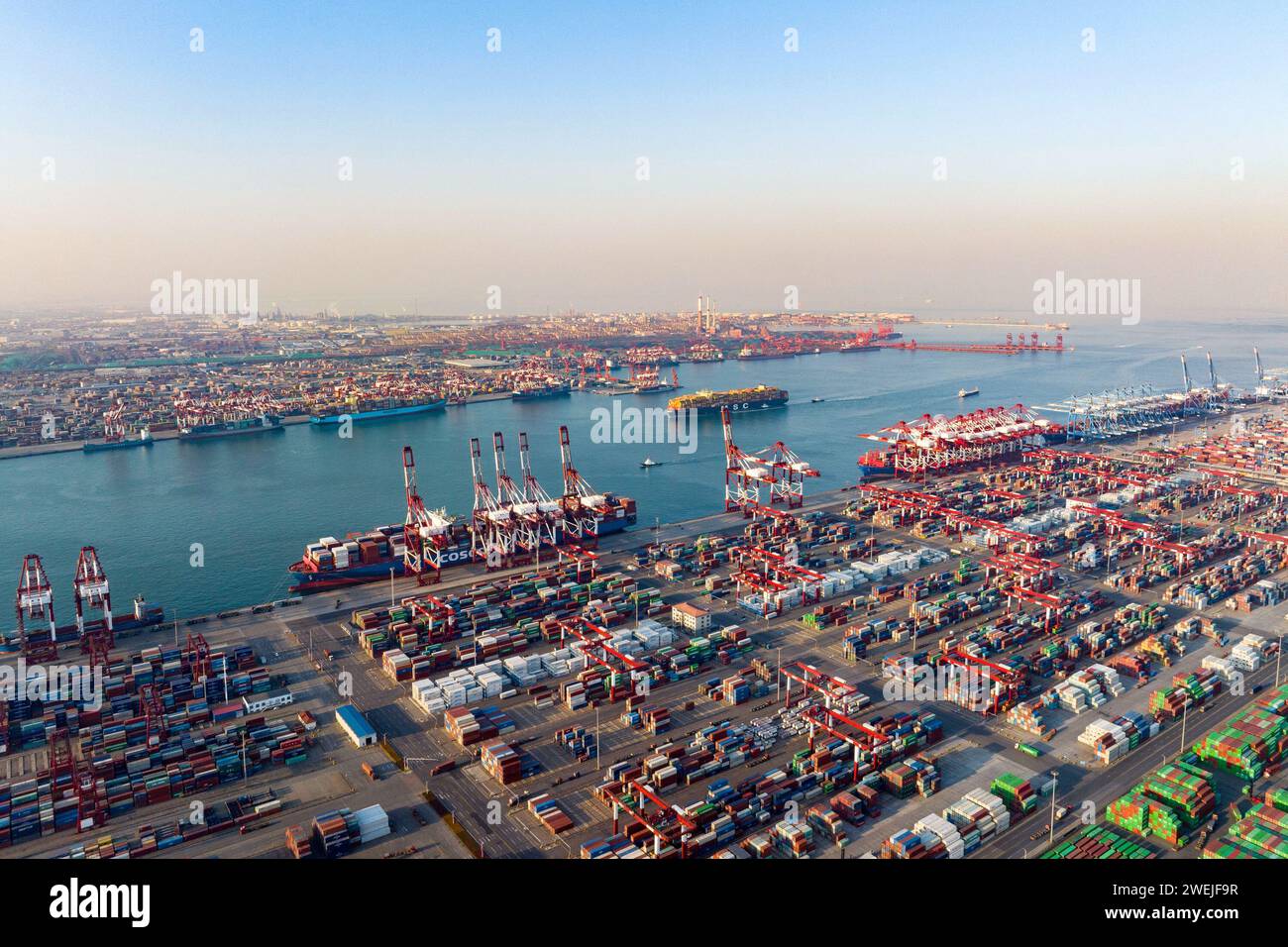 QINGDAO, CHINA - JANUARY 25, 2024 - Container ships enter and exit the ...