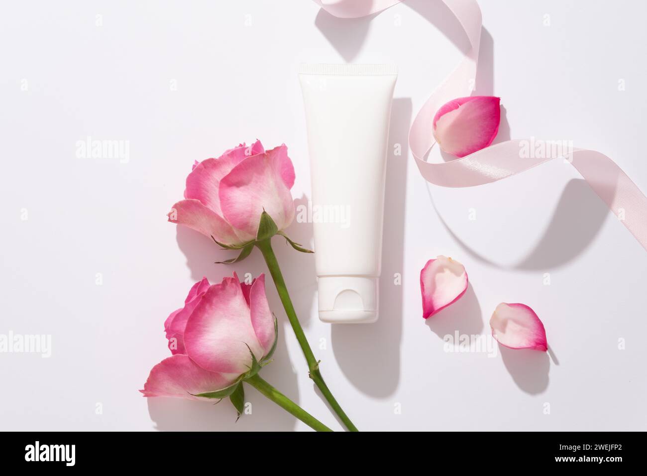 Advertising scene for cosmetics with rose extract. White plastic tube ...
