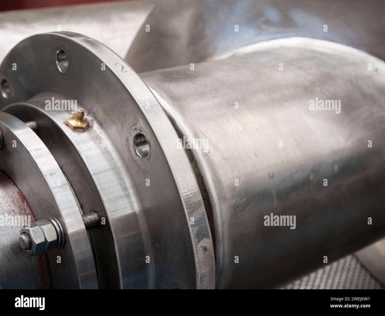 Closeup of drive shaft, flange, grease nipple and screw of a twin screw ...