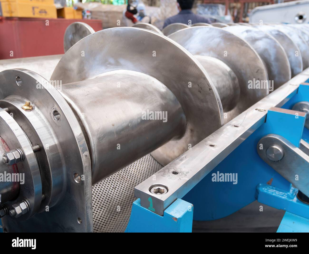 Closeup of drive shaft, flange, grease nipple and screw of a twin screw ...